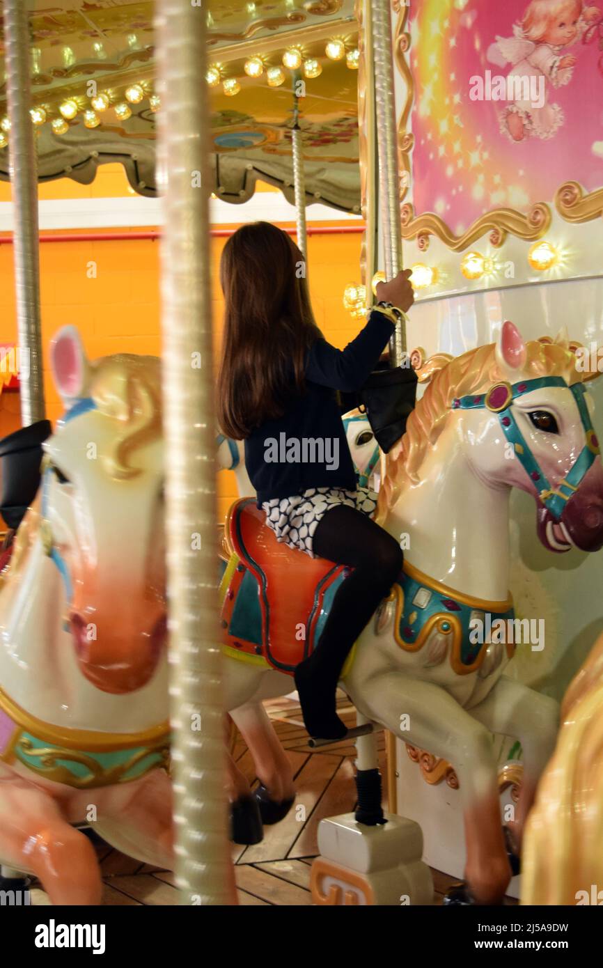 Young girl having fun on a Carousel, horse riding from carousel ...