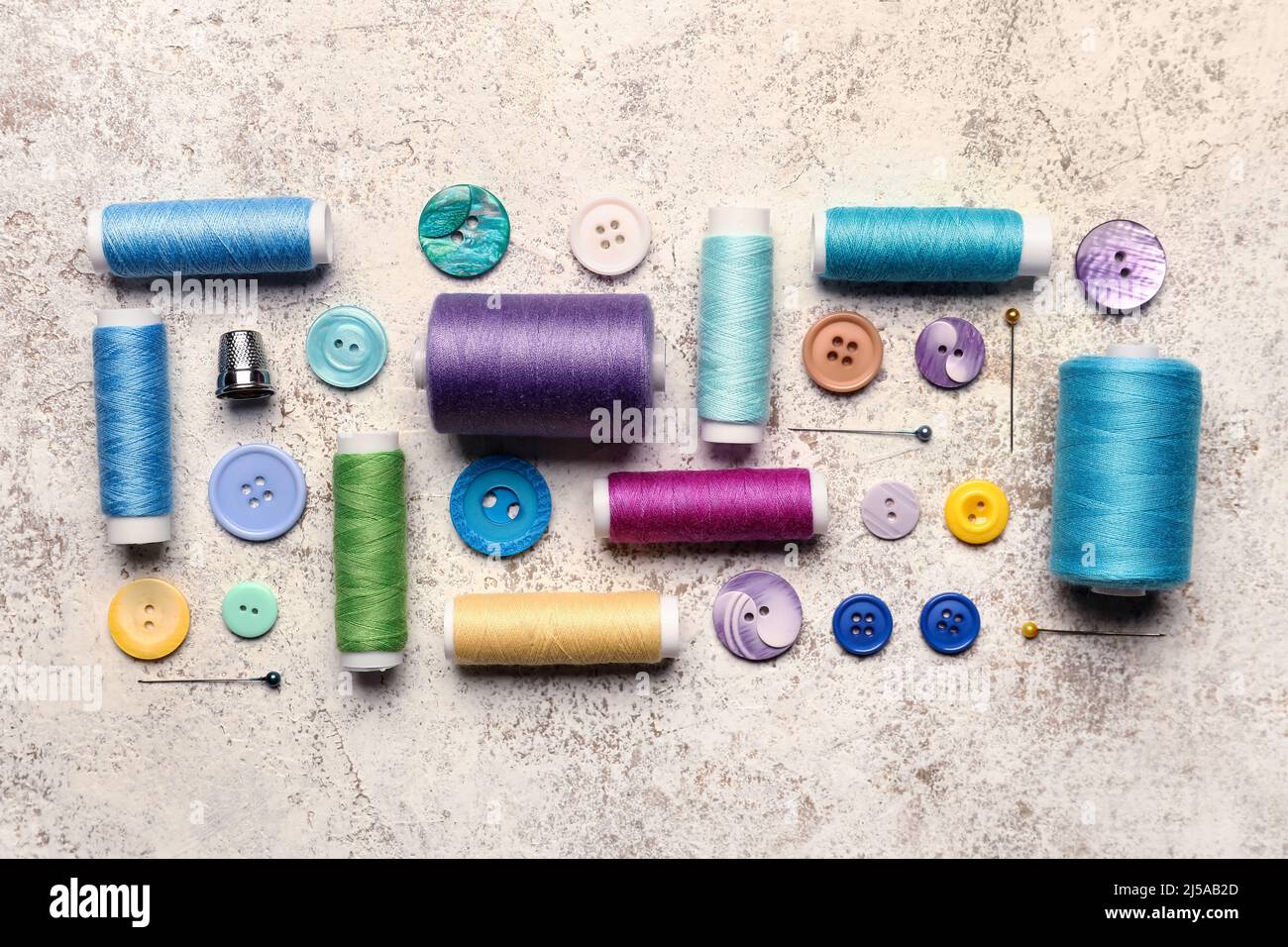 Sewing threads with buttons on light background Stock Photo - Alamy