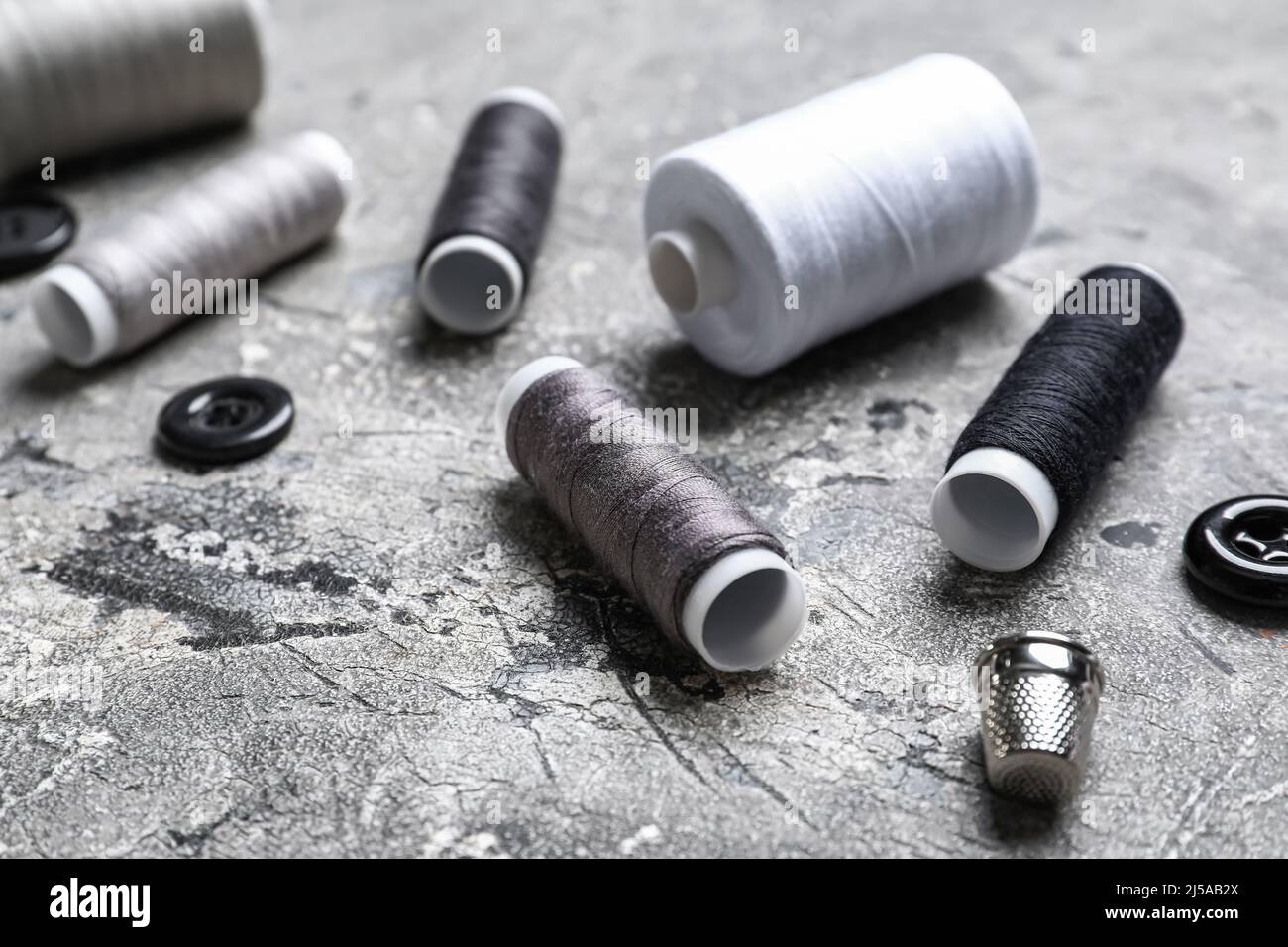 Sewing threads and buttons on grey background, closeup Stock Photo - Alamy