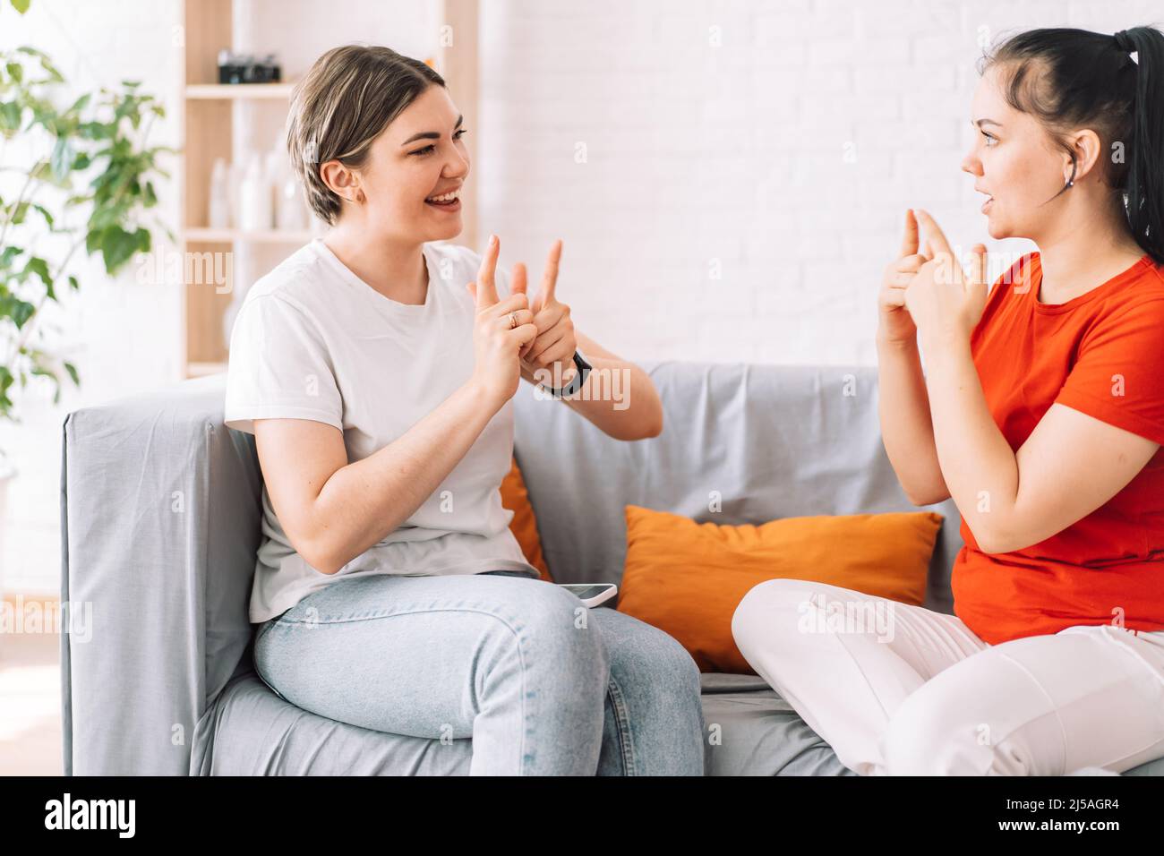 Two girls talking in sign language Stock Photo - Alamy