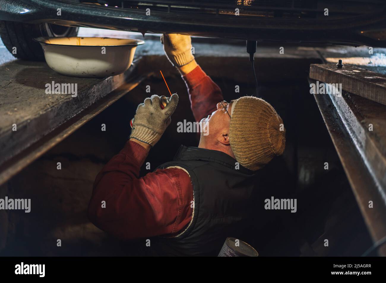 Mechanic cleans the engine pan with special solution Stock Photo - Alamy