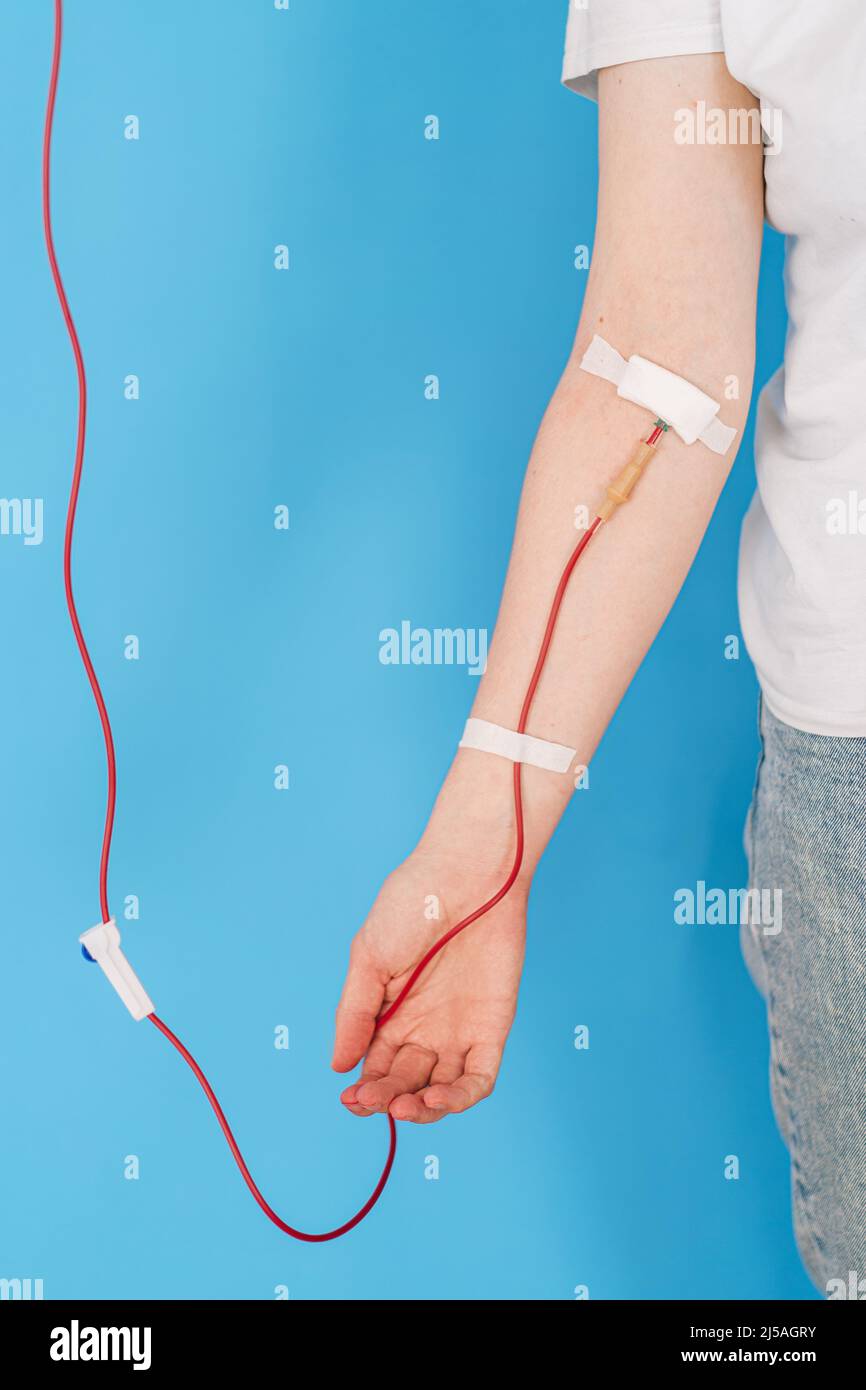 Hand with infusion set for blood collection Stock Photo - Alamy