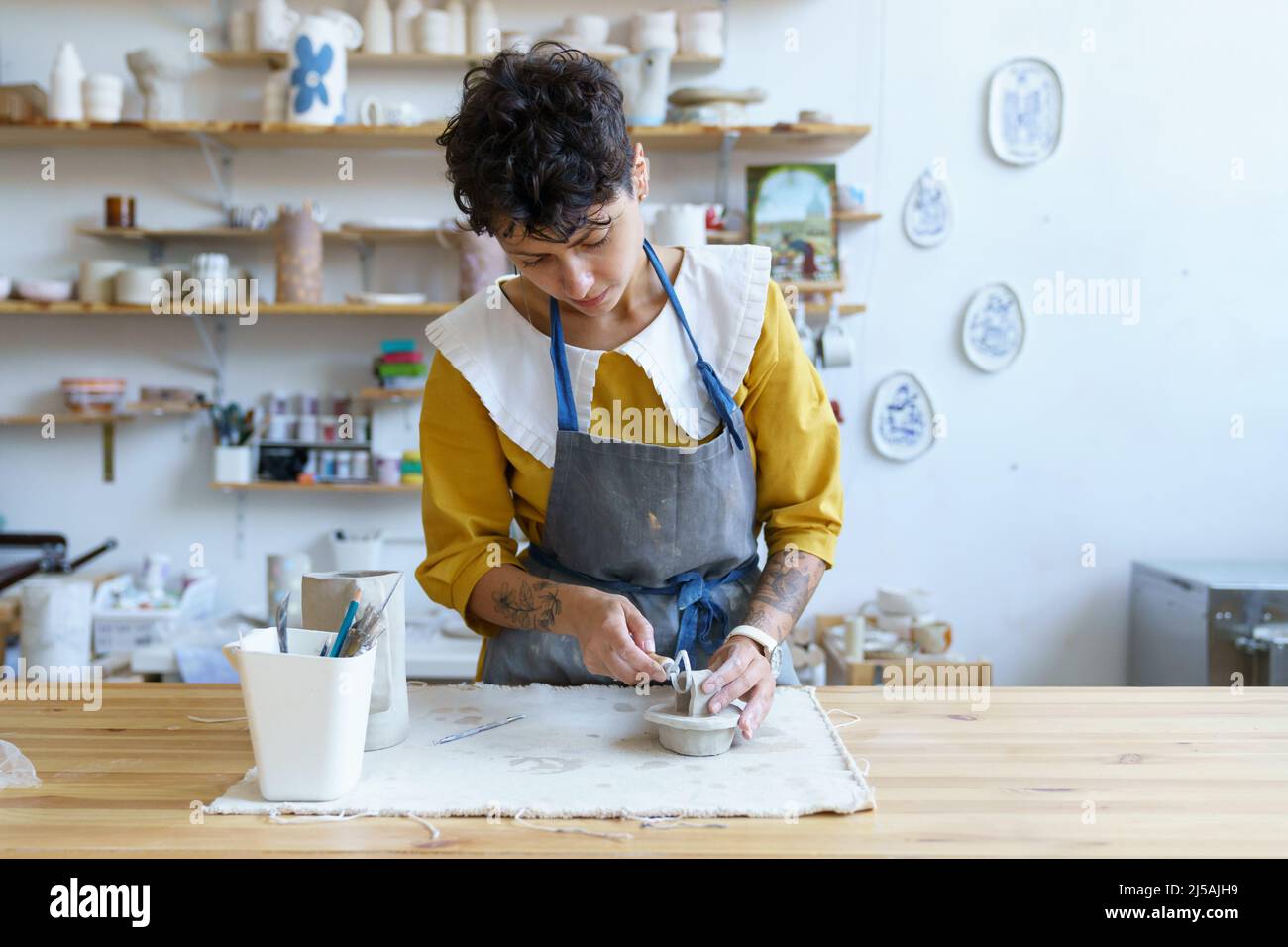 Creative process in pottery studio: young artist girl modeling ...
