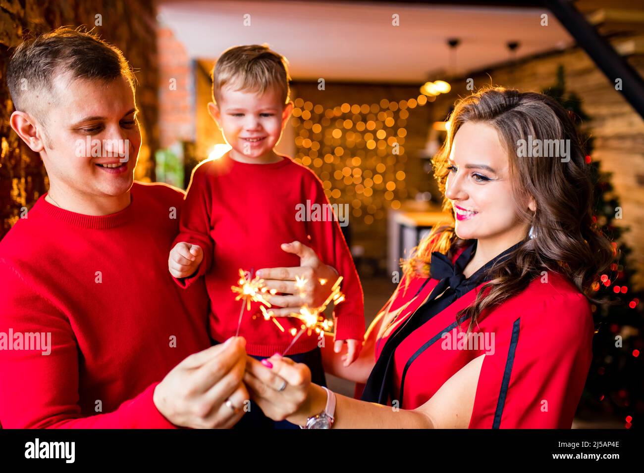 Parents celebrating New Years Eve at home with kid in living room Stock ...