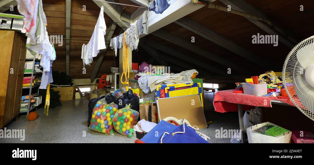 interior of a large attic of a school with old junk toys and hanging ...