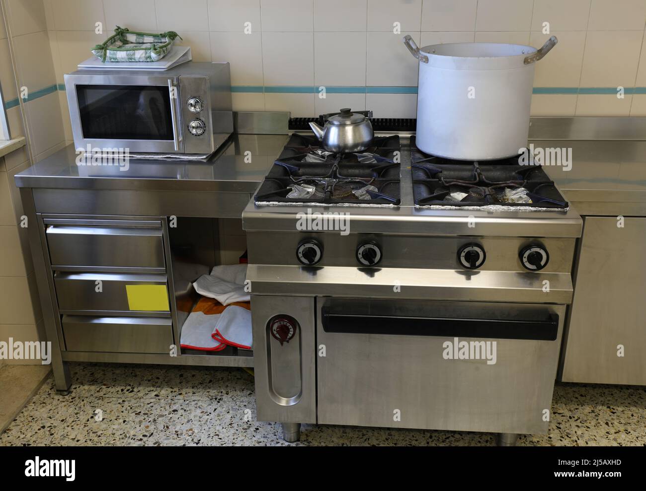 interior of an industrial kitchen with the large aluminum pot above the ...