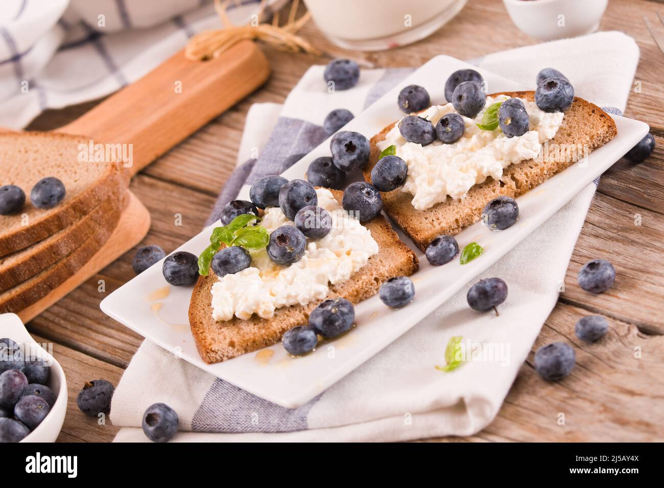 Rye bread with cottage cheese, blueberries and honey Stock Photo - Alamy