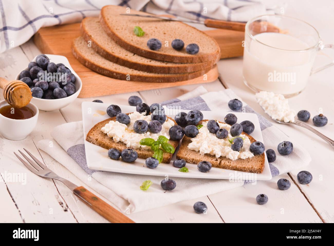 Rye bread with cottage cheese, blueberries and honey Stock Photo - Alamy