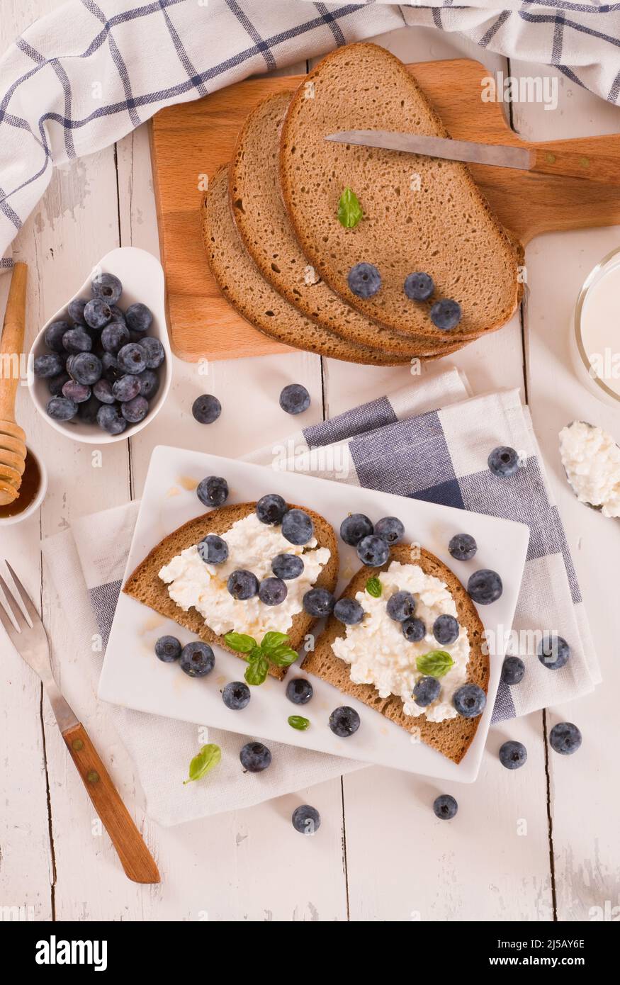 Rye bread with cottage cheese, blueberries and honey Stock Photo - Alamy