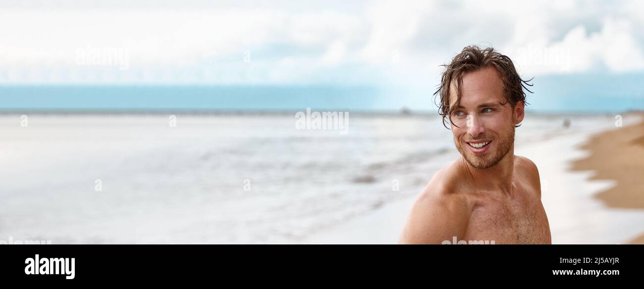 Handsome good looking man swimming at beach looking to the side on copy ...