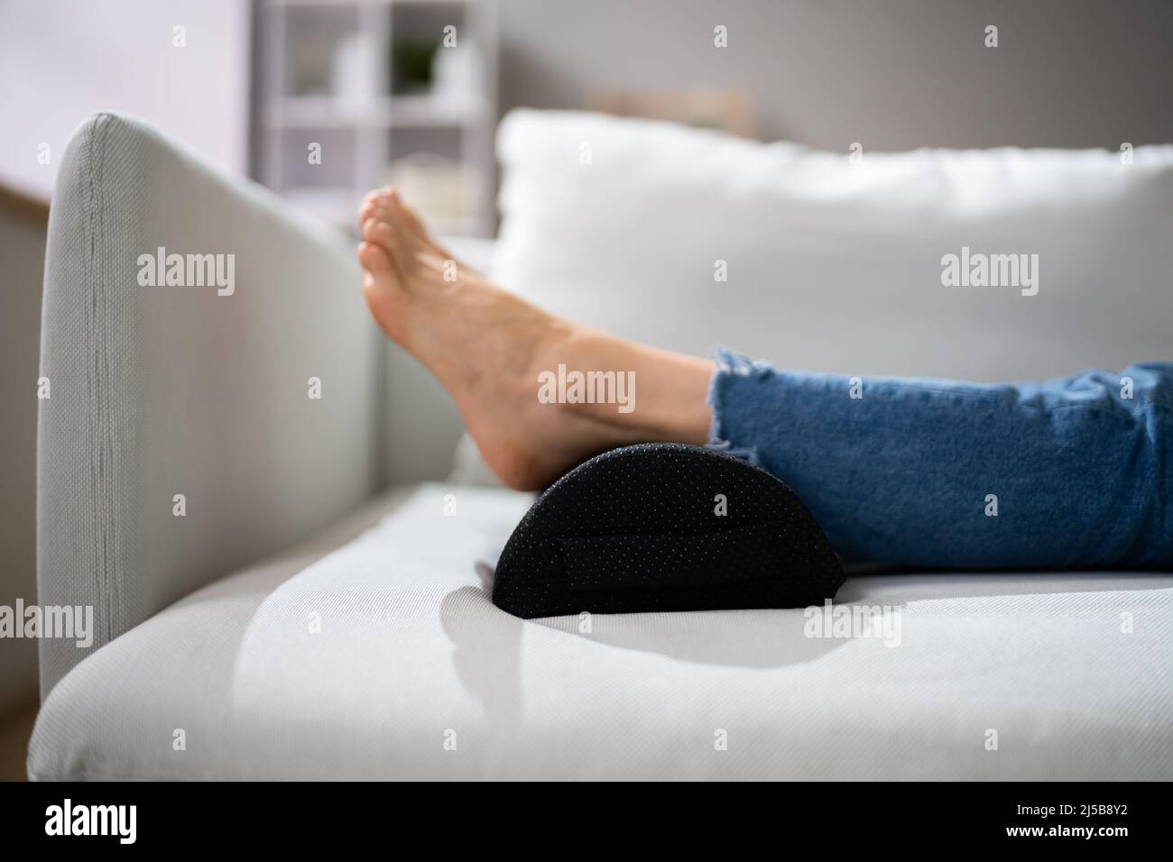Woman Using Footrest To Reduce Back Strain And Feet Fatigue Stock Photo ...