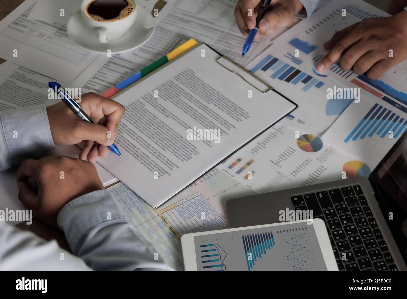 Businessman working on laptop computer on desk document signing ...