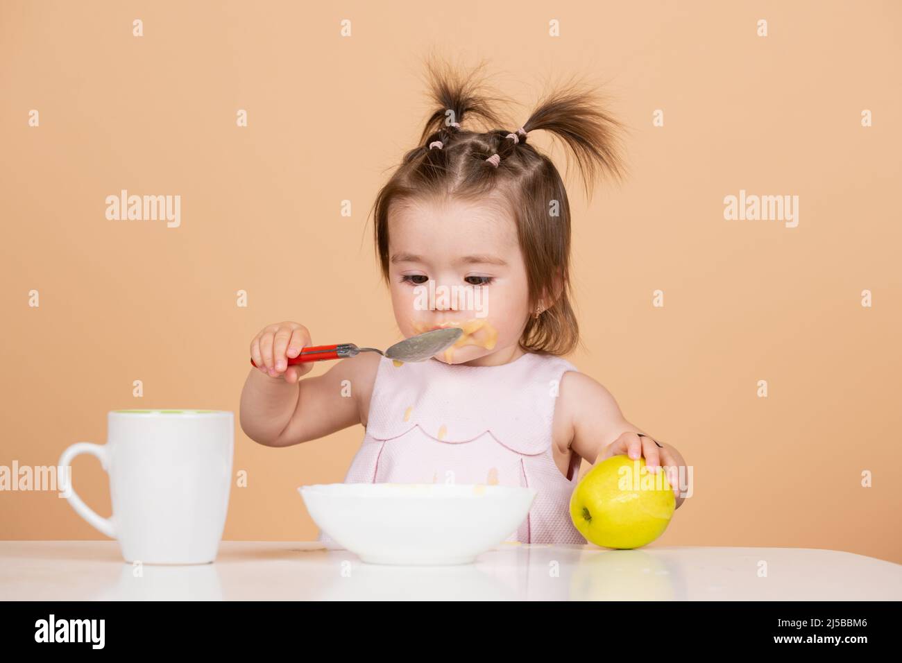 Baby child eating food. Little baby eating fruit puree Stock Photo - Alamy