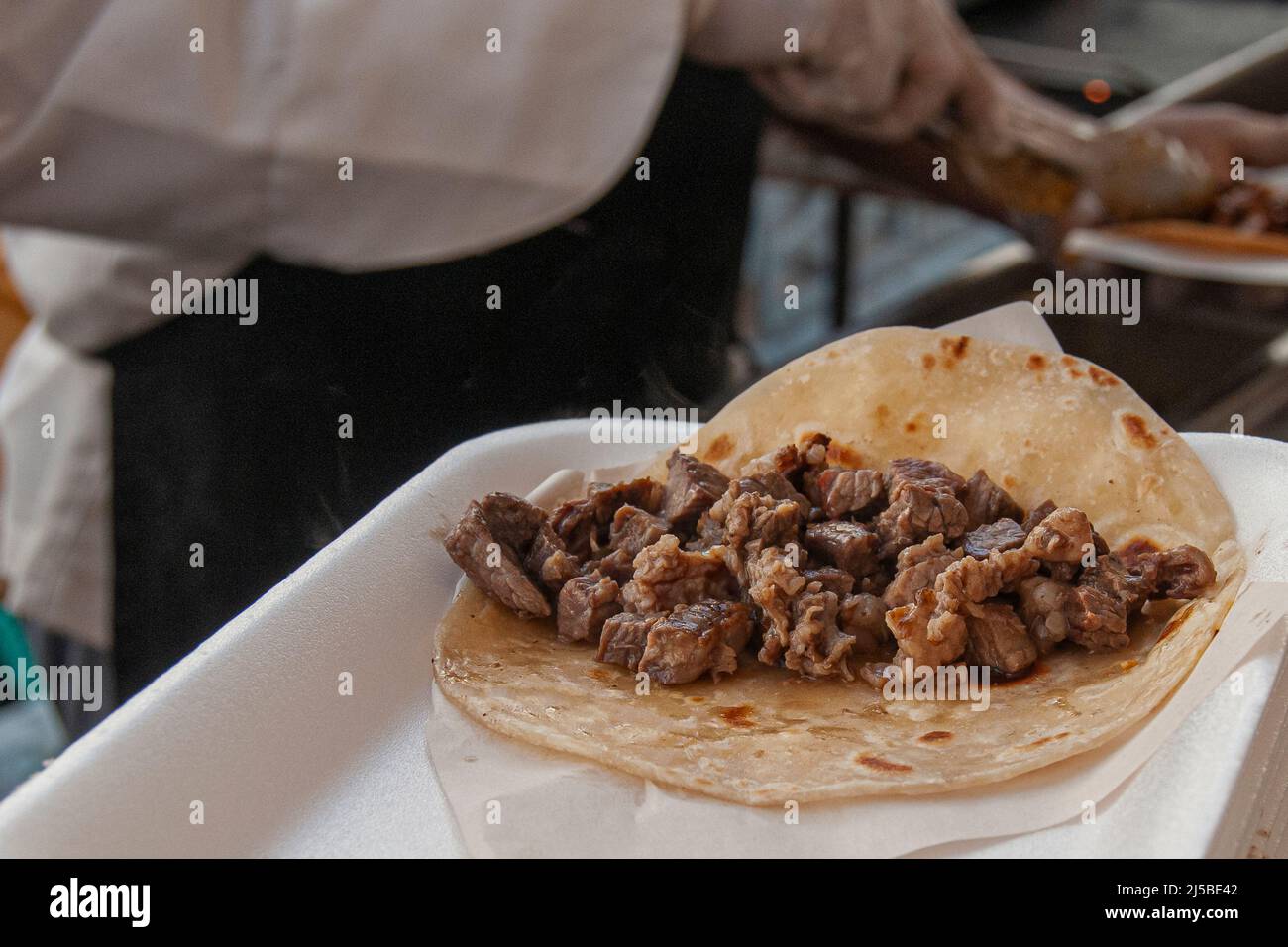 Taco man or TAQUERO preparing tacos on the street as part of the street ...