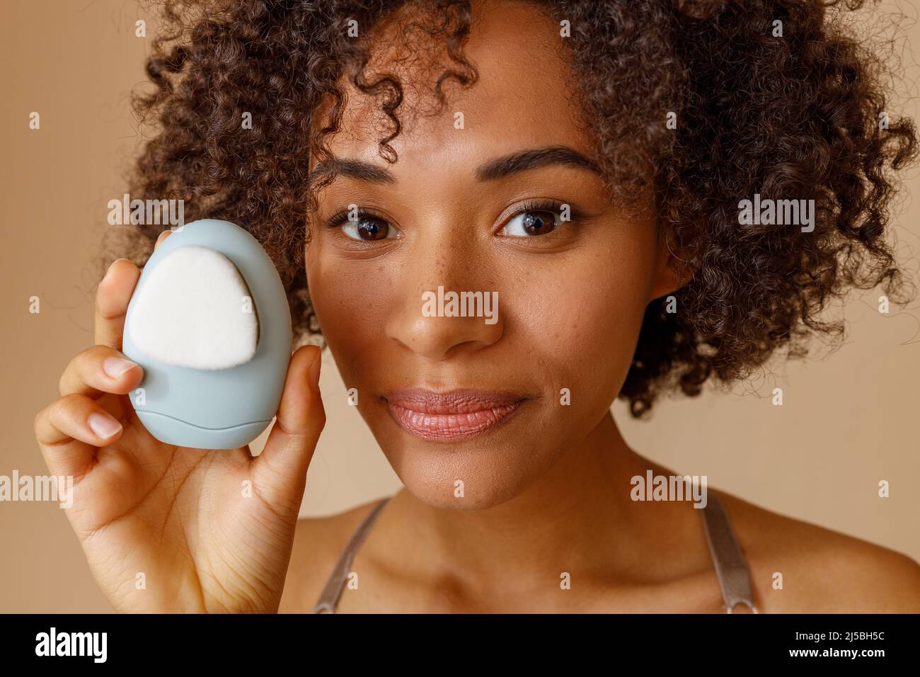 Cute lady representing cosmetic tool in studio Stock Photo - Alamy