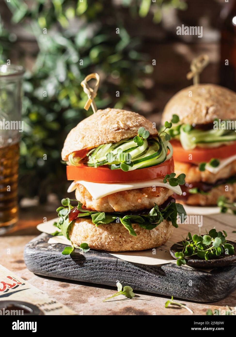 Two delicious homemade burgers of beef, cheese and vegetables and ...