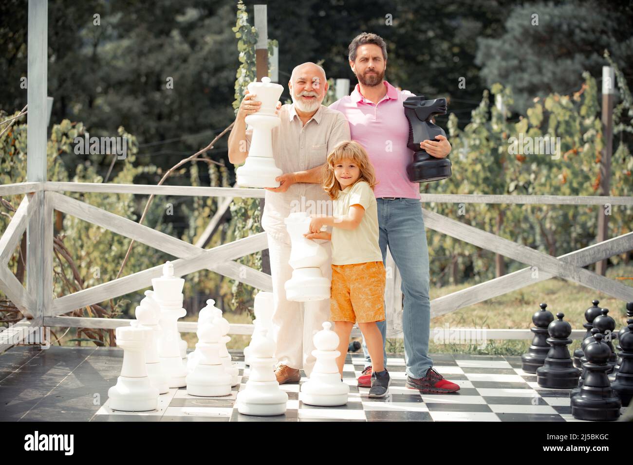 Men generation grandfather father and son playing chess. Developing ...