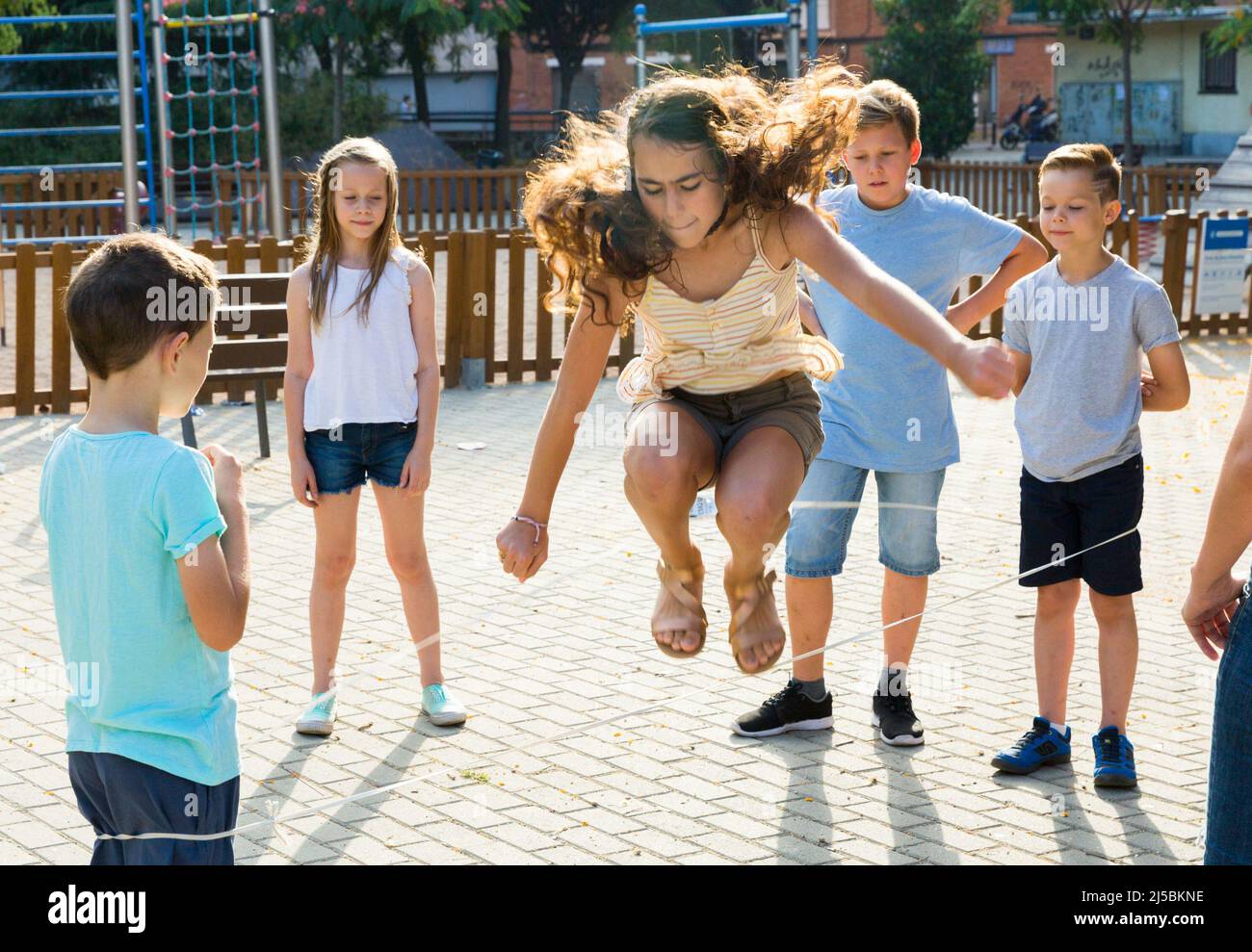 Happy children skipping on jumping elastic rope Stock Photo - Alamy