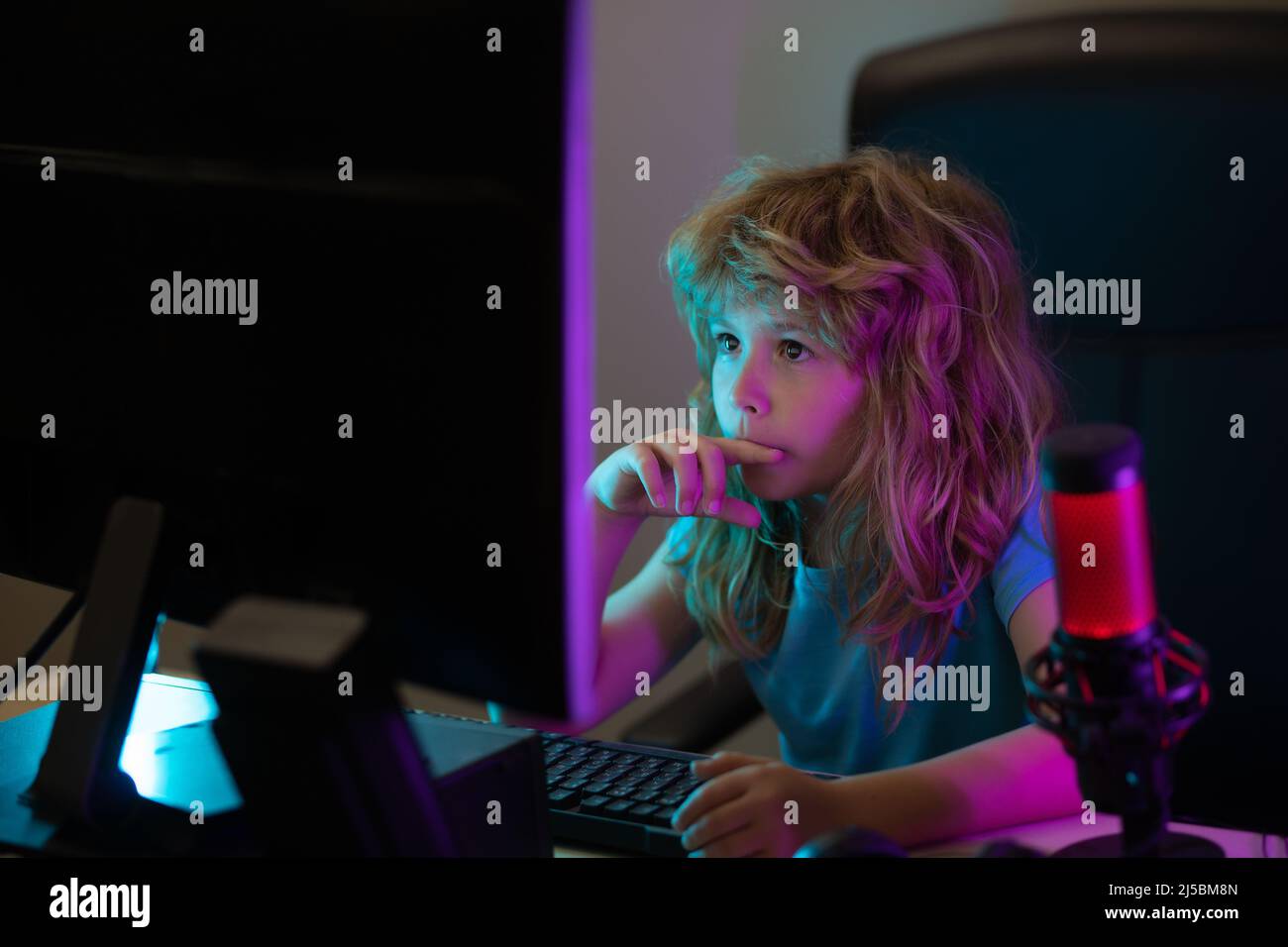 Little kid using desktop pc by night, child boy illuminated by the blue ...