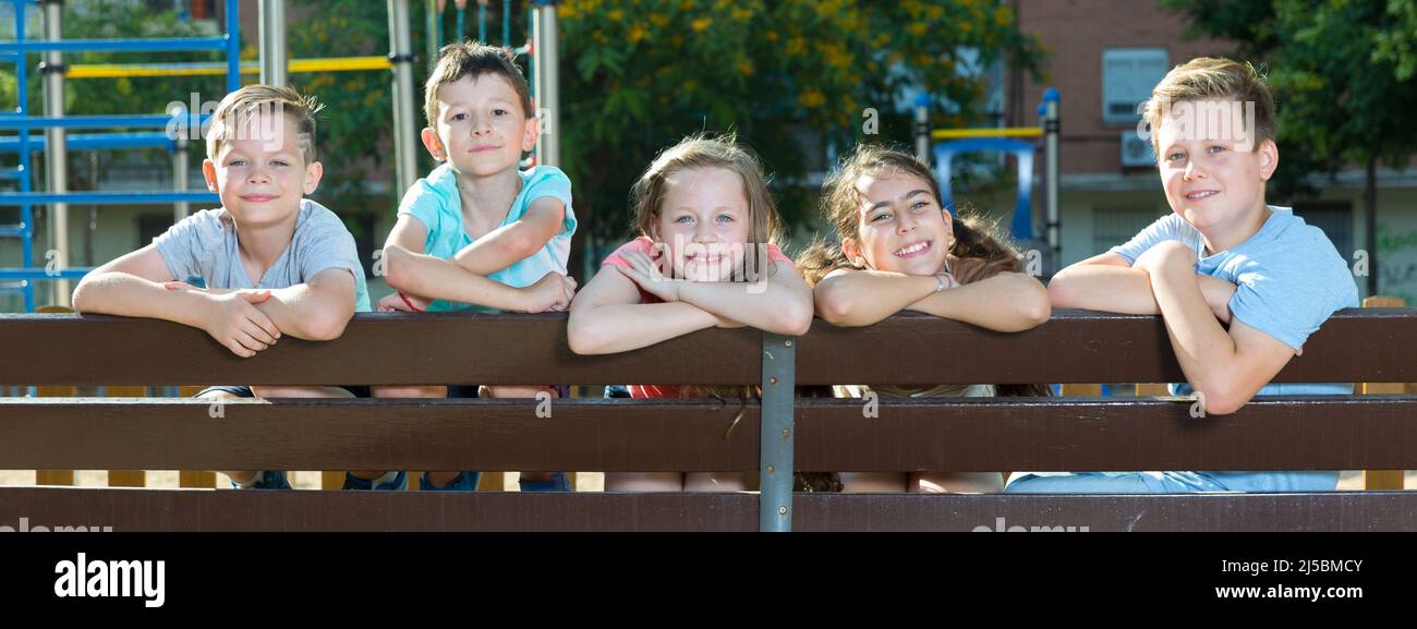 Glad children sitting on a bench Stock Photo - Alamy