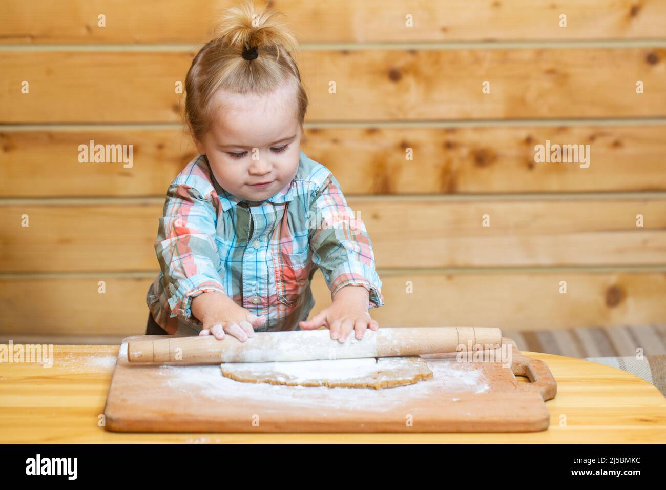 Little baker child at kitchen. Baby boy in the kitchen helping with ...