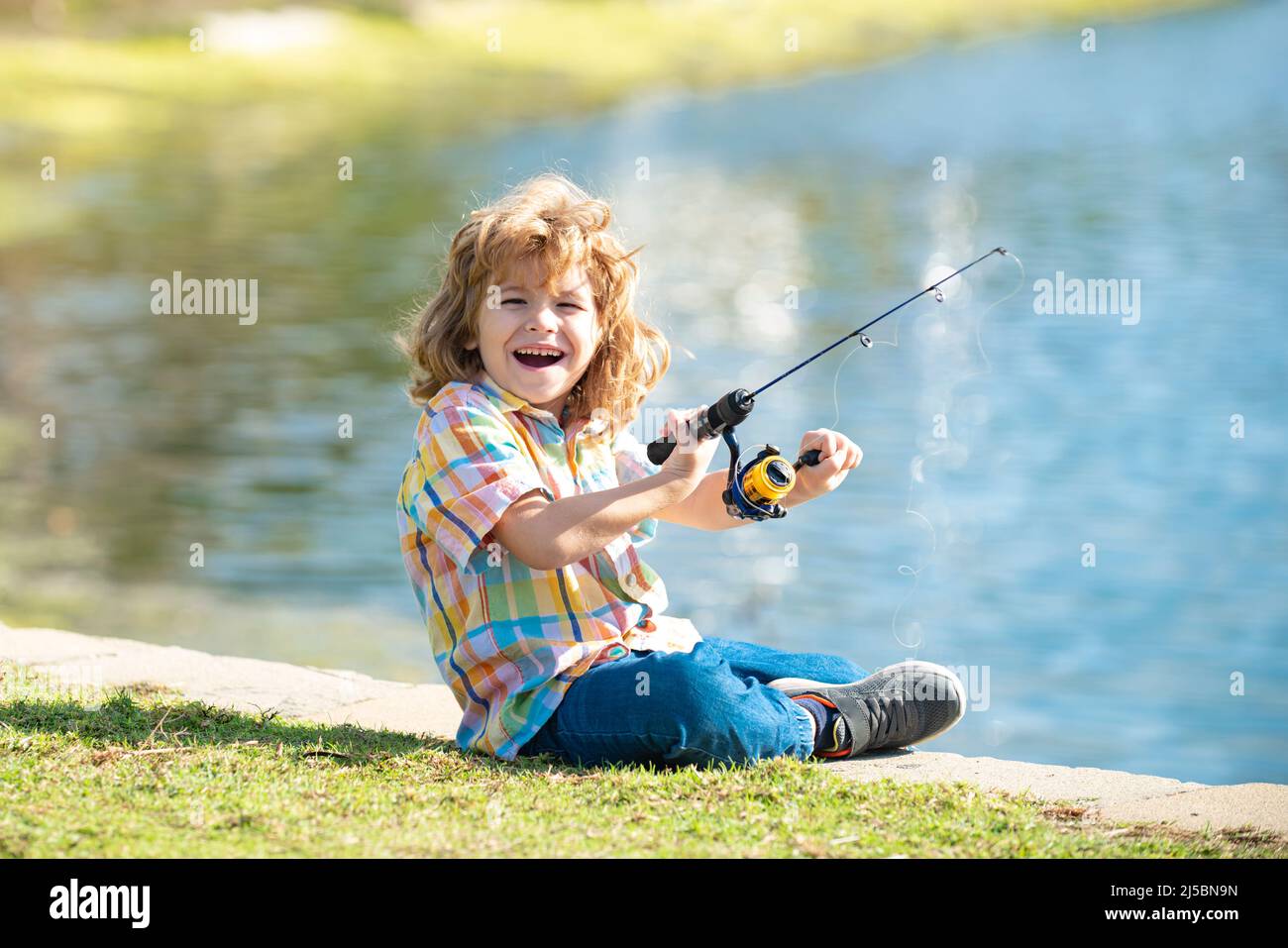 Funny happy little kid fishing on weekend. A fisherman boy stands in ...