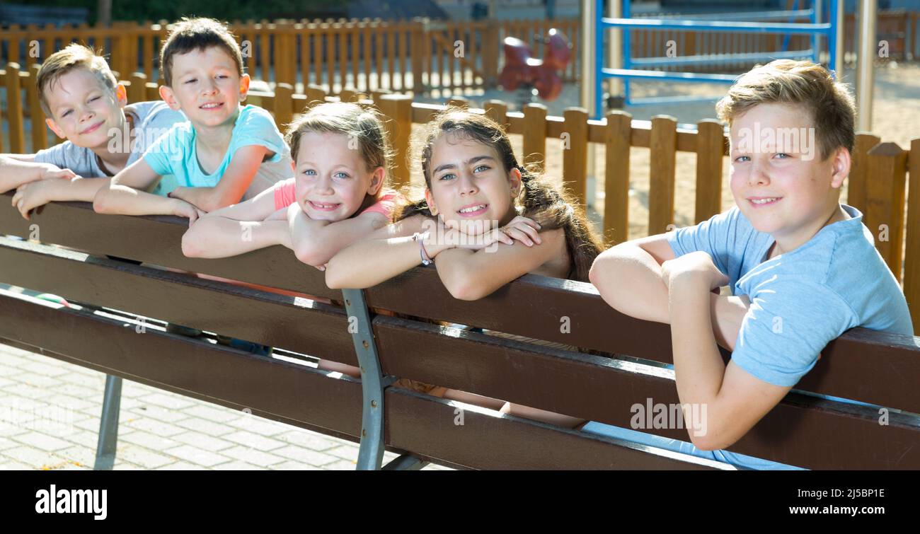 Five glad children sitting on a bench Stock Photo - Alamy