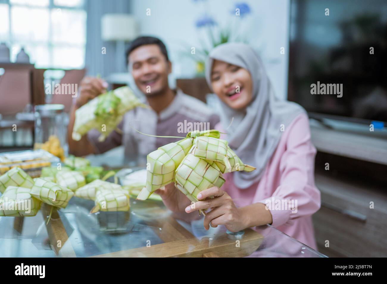 muslim couple asian making ketupat rice cake at home using palm leaf ...