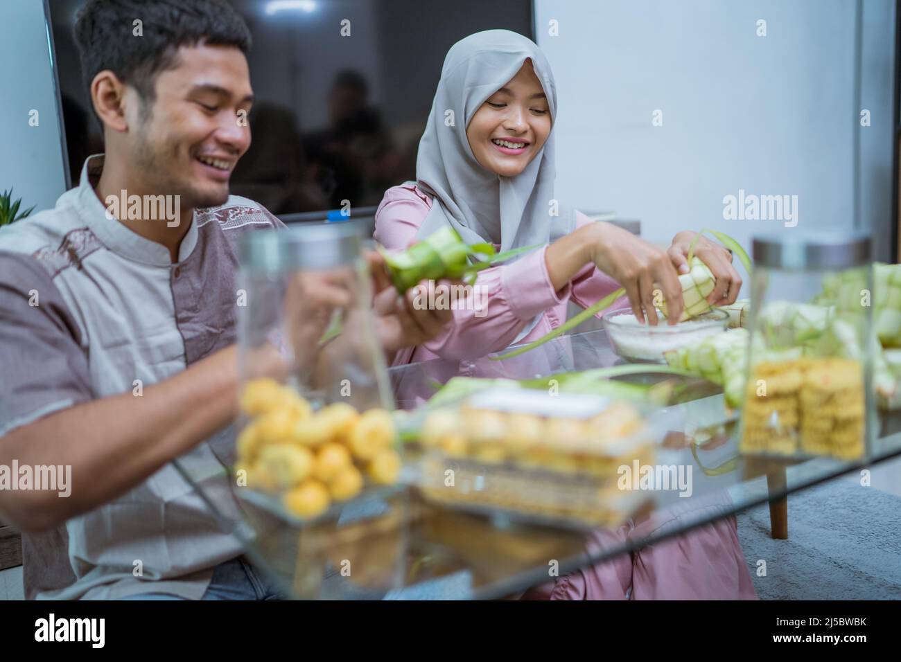 muslim couple asian making ketupat rice cake at home using palm leaf ...