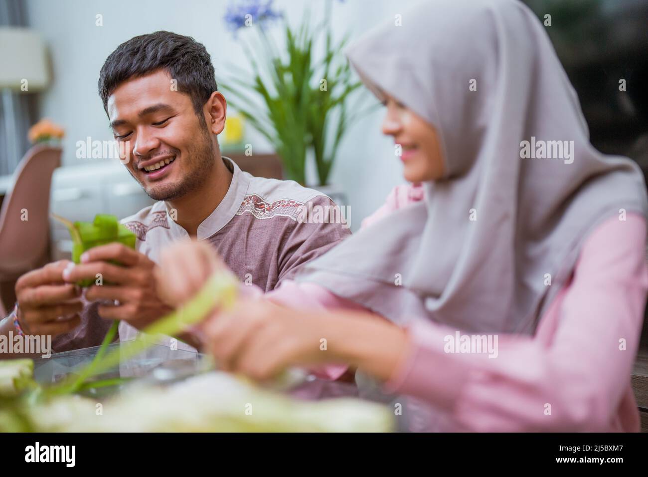 muslim couple asian making ketupat rice cake at home using palm leaf ...