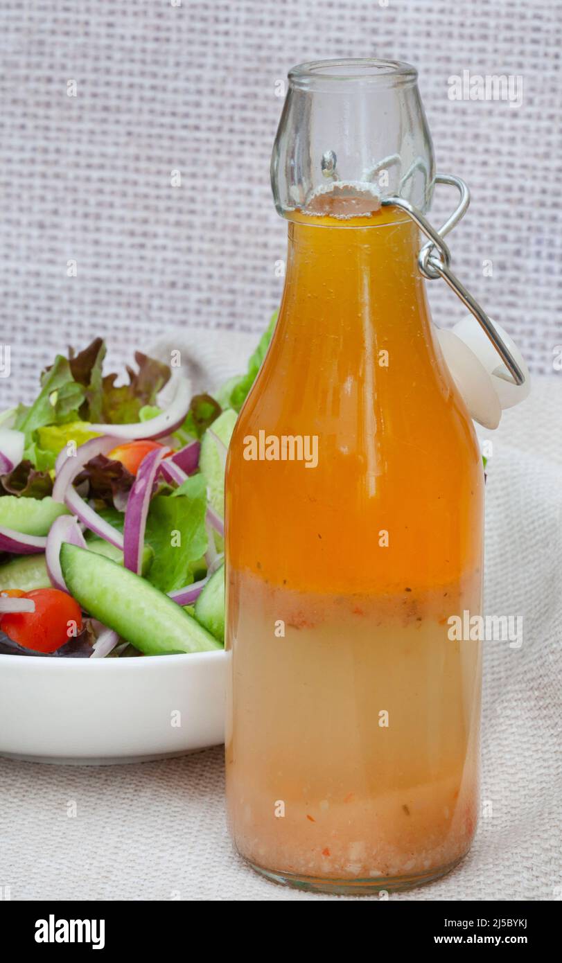 homemade salad dressing with side salad on rustic table with copy space ...