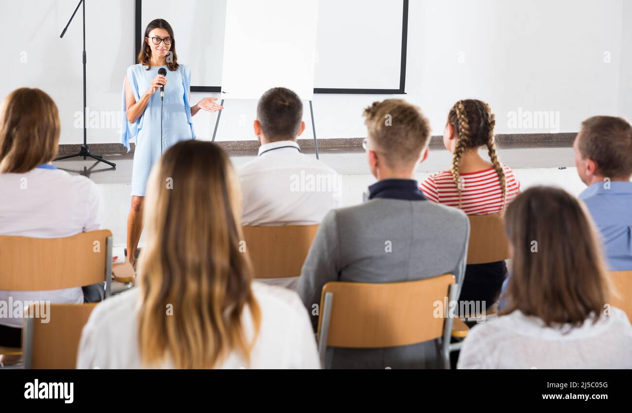 Female student answering in front of student group Stock Photo - Alamy