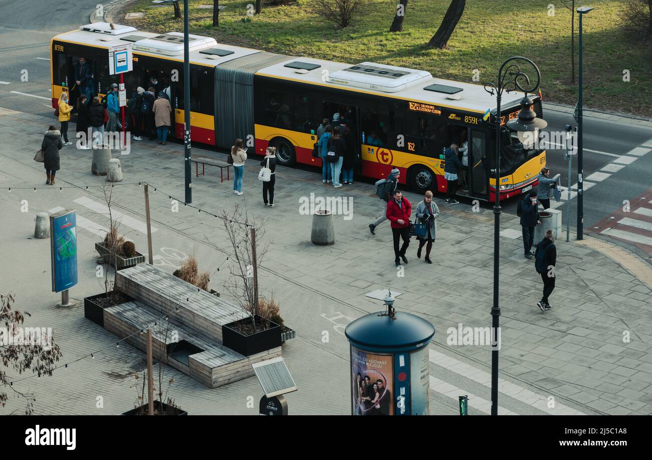 Warsaw. Poland. 03.30.2022. Elongated city bus at the bus stop. People ...