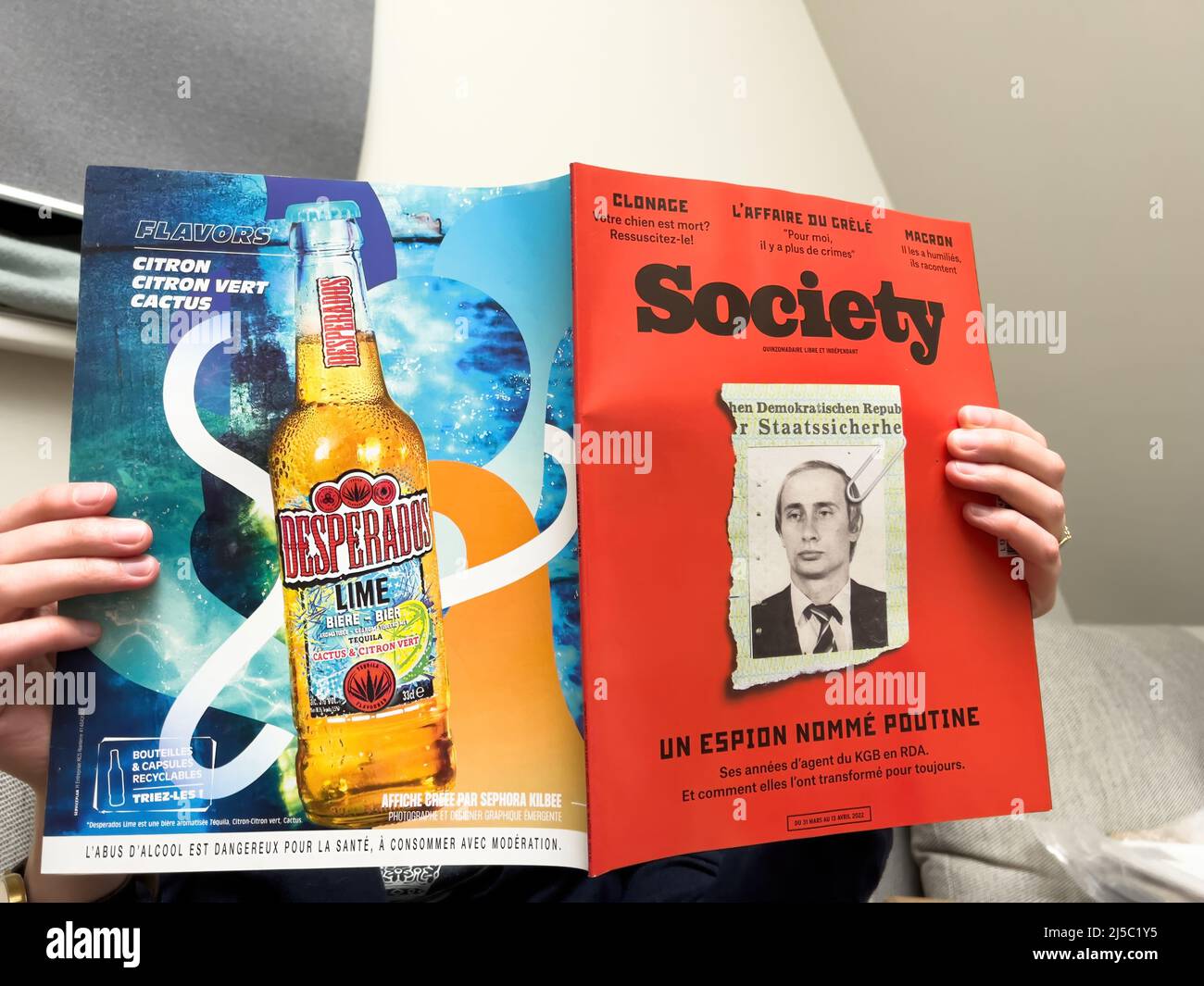Paris, France - Apr 21, 2022: Woman reading on the living room couch ...