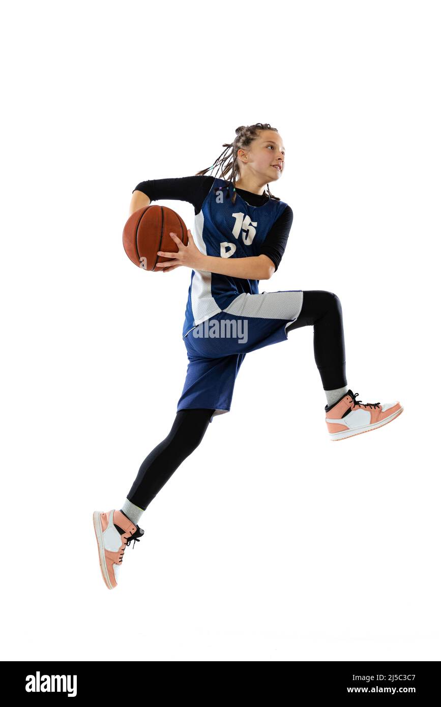 Throwing ball in a jump. Portrait of teen girl in blue uniform training ...