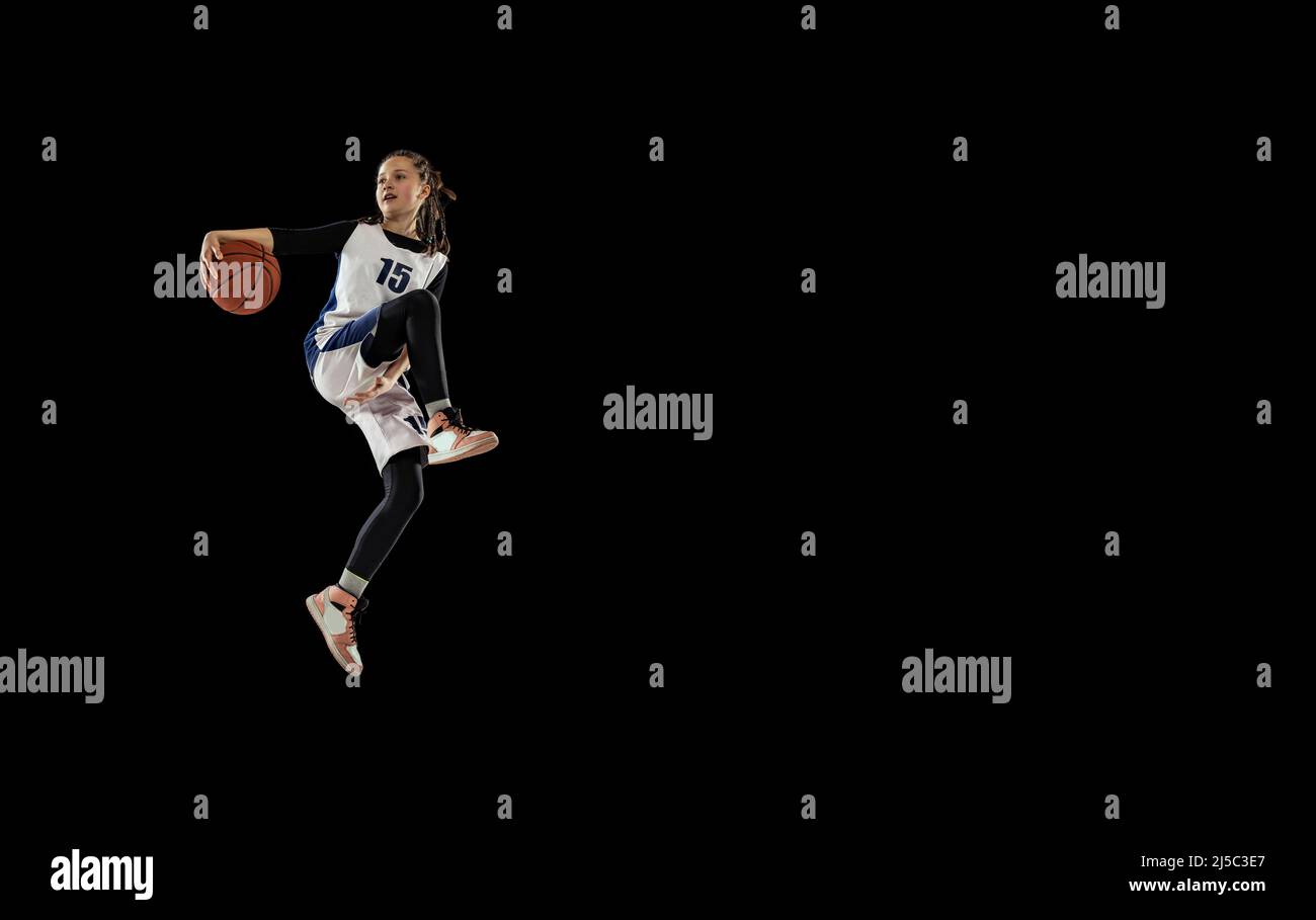 Throwing ball in a jump. Goal scoring. Portrait of teen girl in blue ...