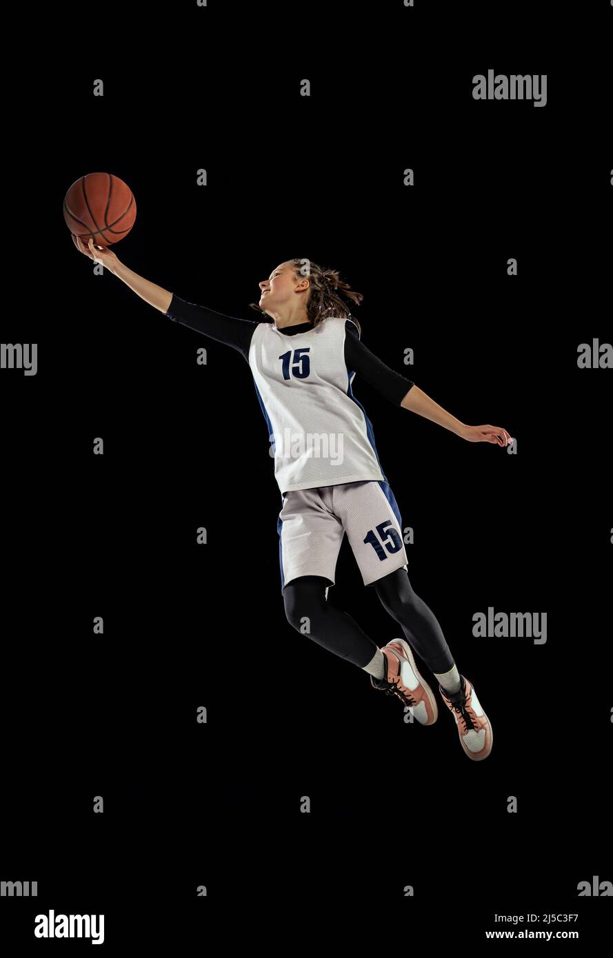 Portrait of sportive teen girl, basketball player training, scoring a ...