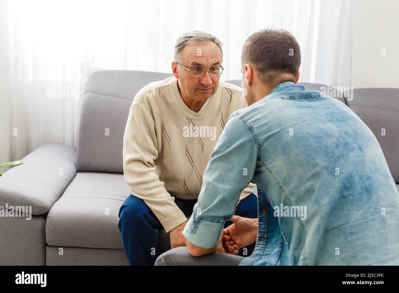Adult Son Talking To Depressed Father At Home Stock Photo - Alamy