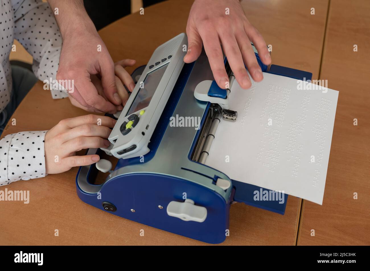 A man teaches a blind woman to type on braille machine Stock Photo - Alamy