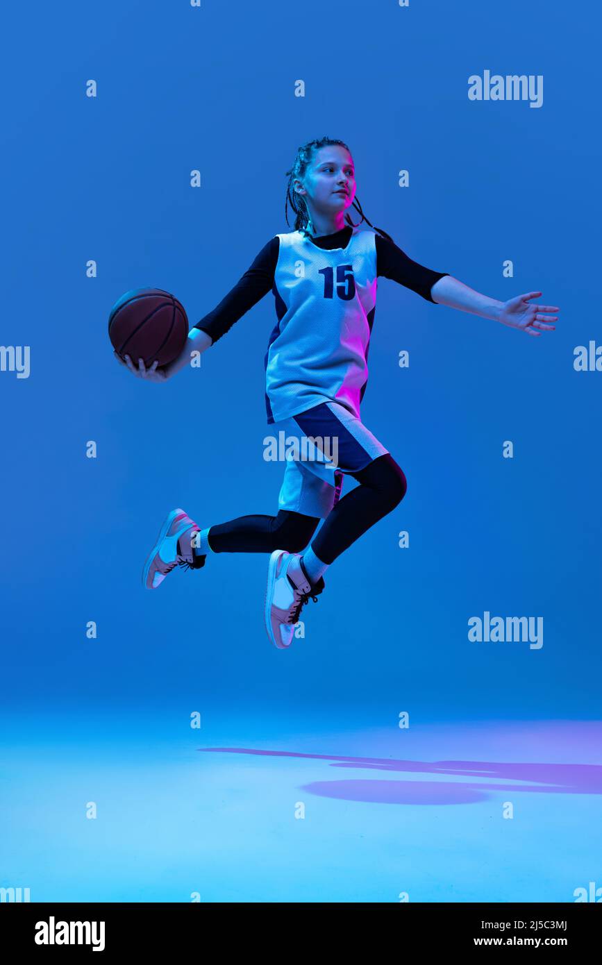 Throwing ball into basket. Portrait of teen girl, basketball player ...