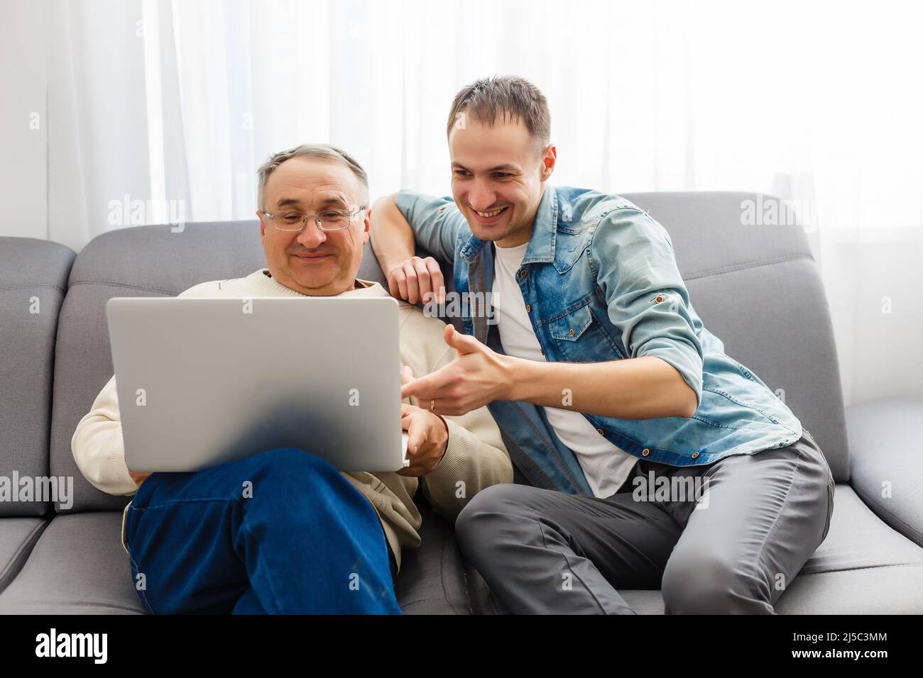 Two men in living room talking Stock Photo - Alamy