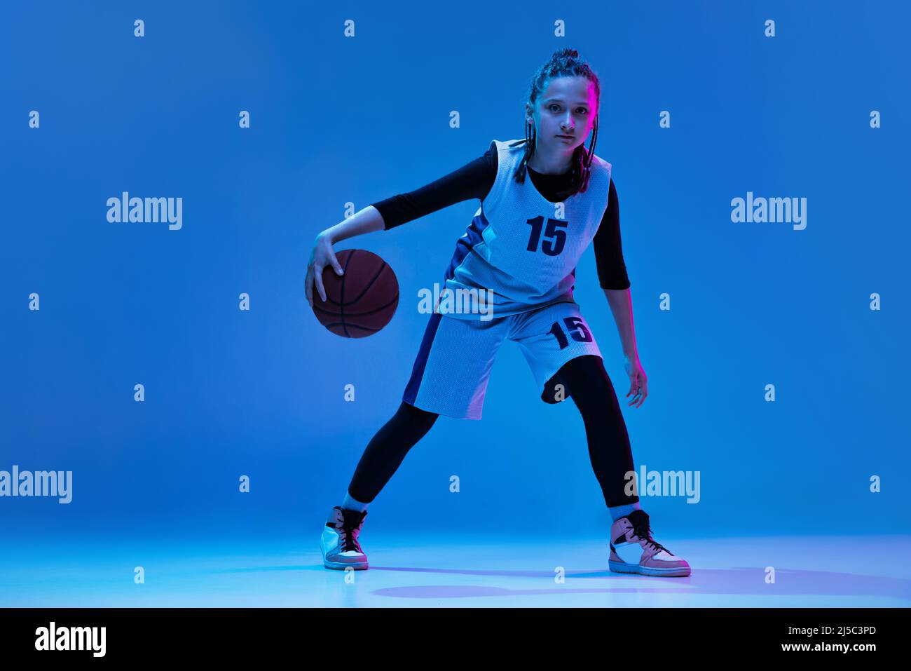 Portrait of teen girl, basketball player in motion, dribbling ball ...