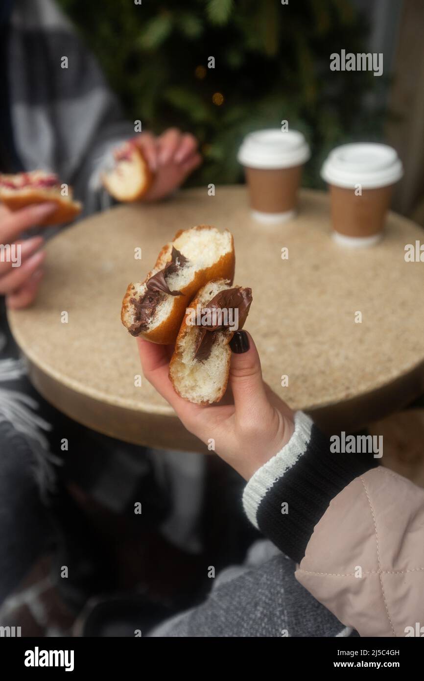 German donuts - berliner with filling and icing sugar in female hands ...