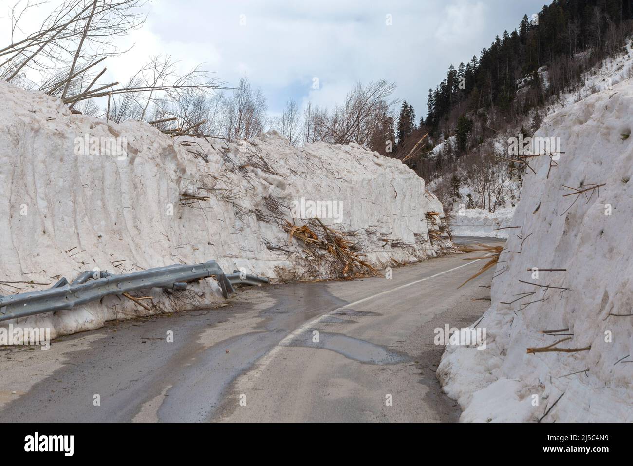 Asphalt road with a high layer of snow on the roadside Stock Photo - Alamy