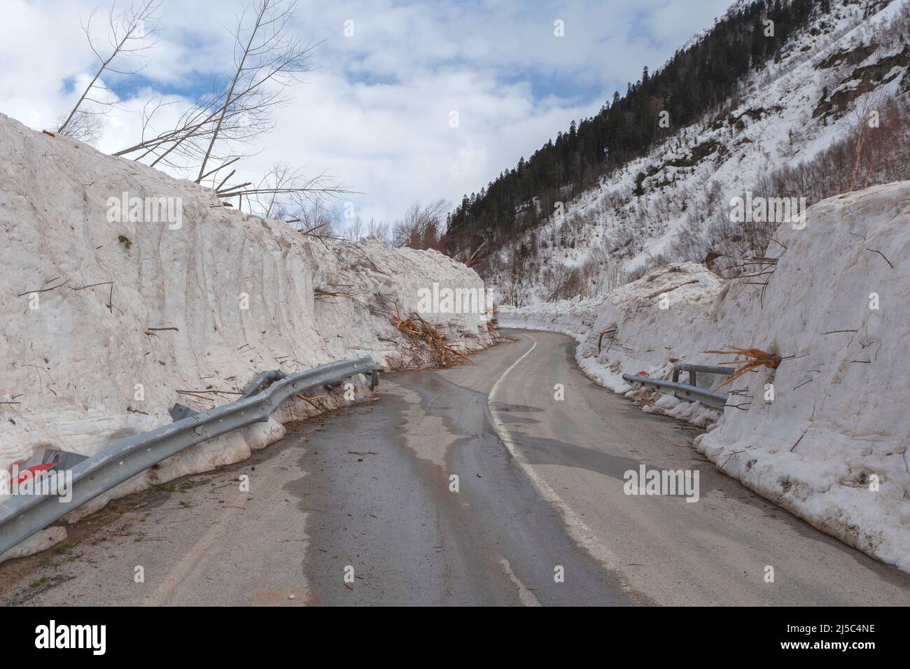 Asphalt road with a high layer of snow on the roadside Stock Photo - Alamy