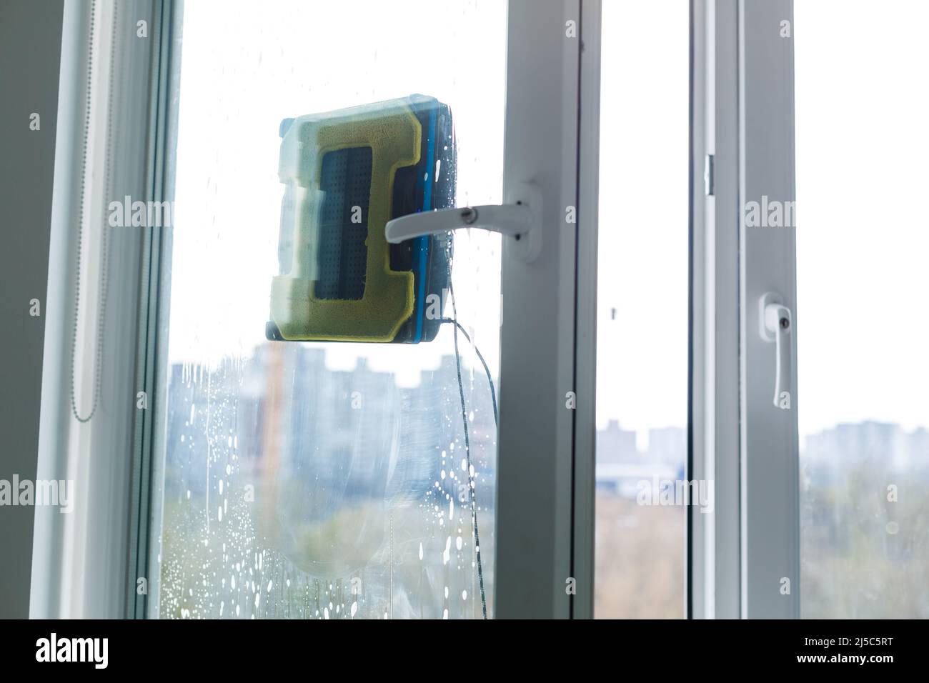 Robot window cleaner work on dirty window. Cleaning the house with ...