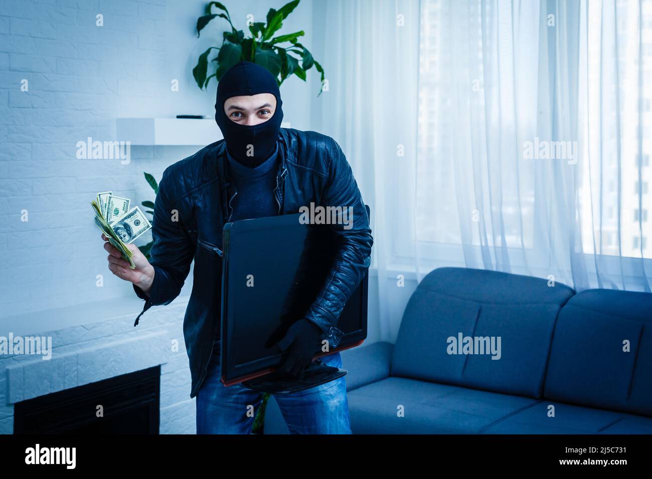Man burglar stealing tv set from house Stock Photo - Alamy