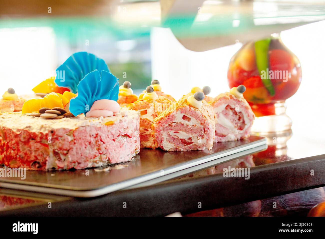 Sponge roll with candied fruits and blueberries. Dessert table in a ...