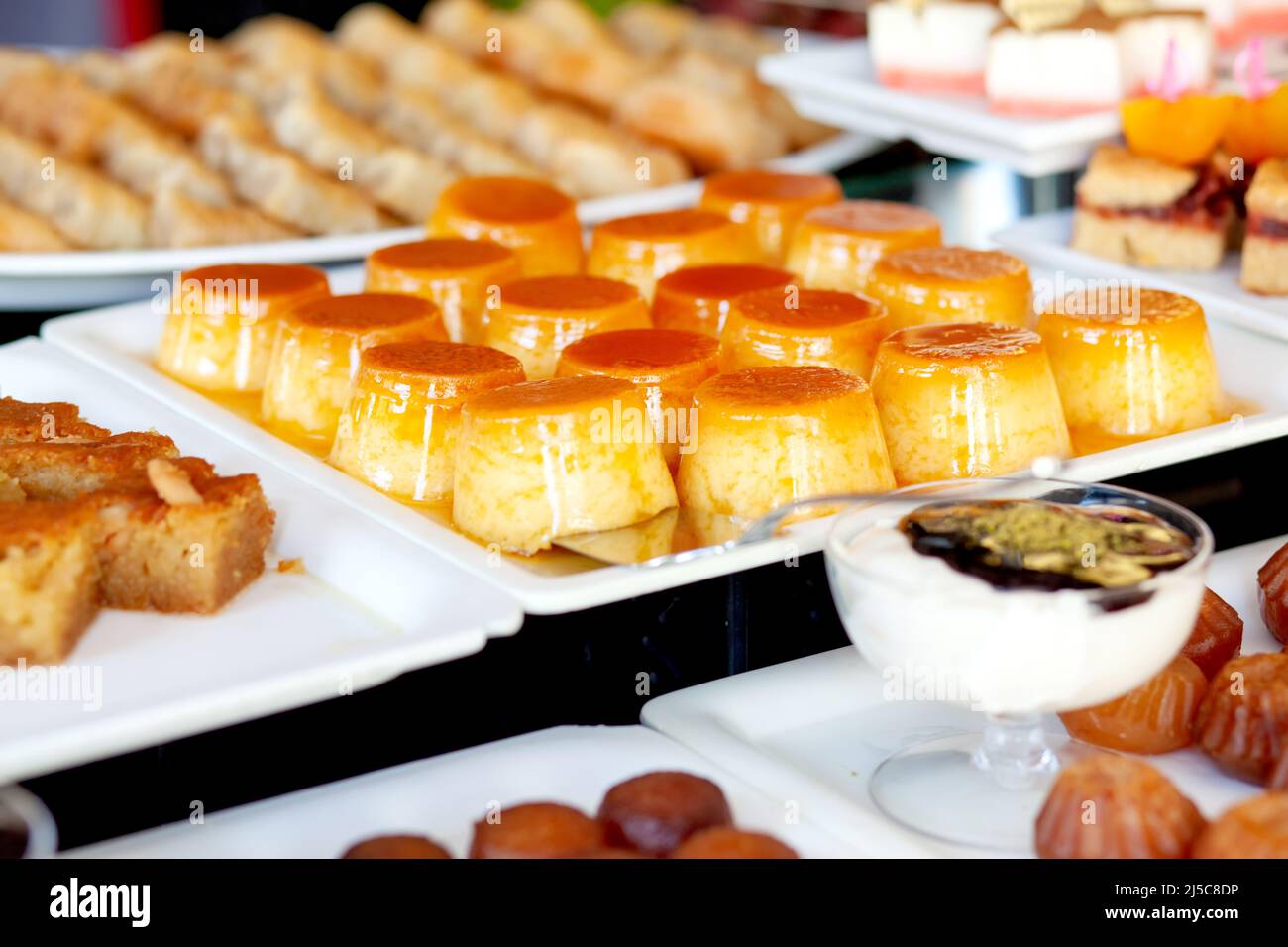Caramel vanilla flan. Dessert table in a Turkish hotel. Various cakes ...