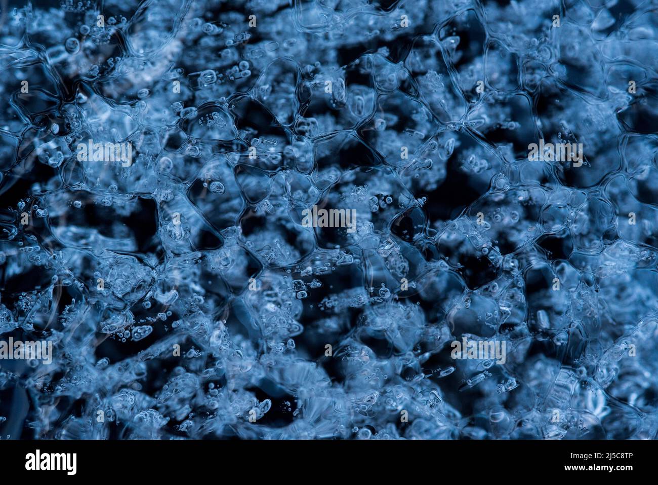Gas bubbles trapped in ice. Blue toned image for abstract background ...